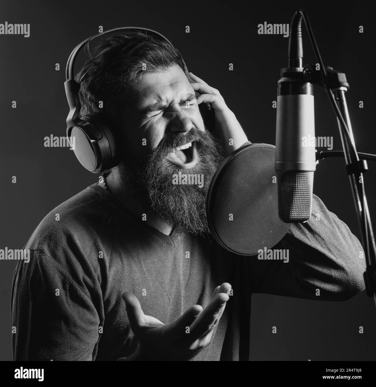 Excited man with microphone singing song. Musician in music hall. Funny ...