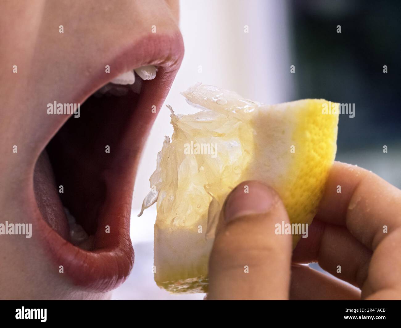lemon food - eating lemon rich in vitamin C, closeup of lips and lemon ...