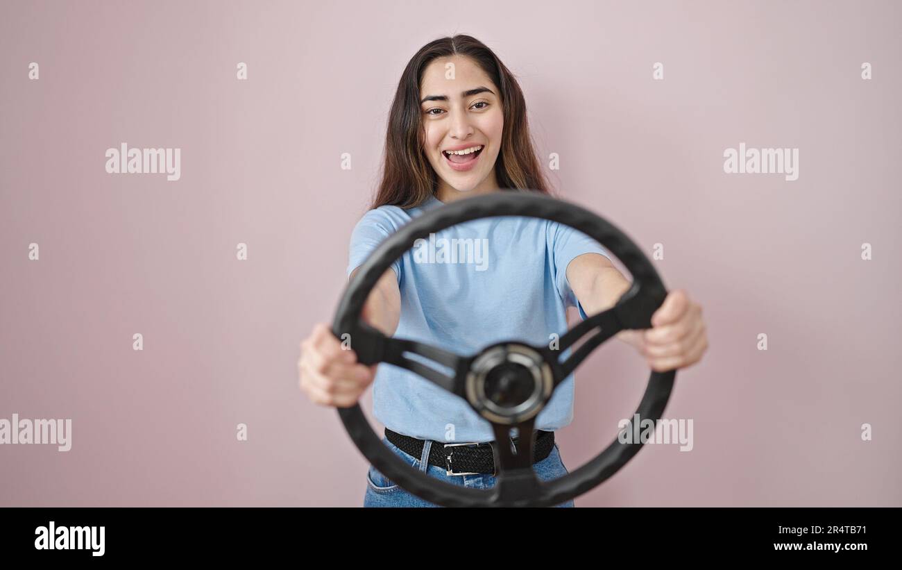 Young beautiful hispanic woman smiling confident using steering wheel ...