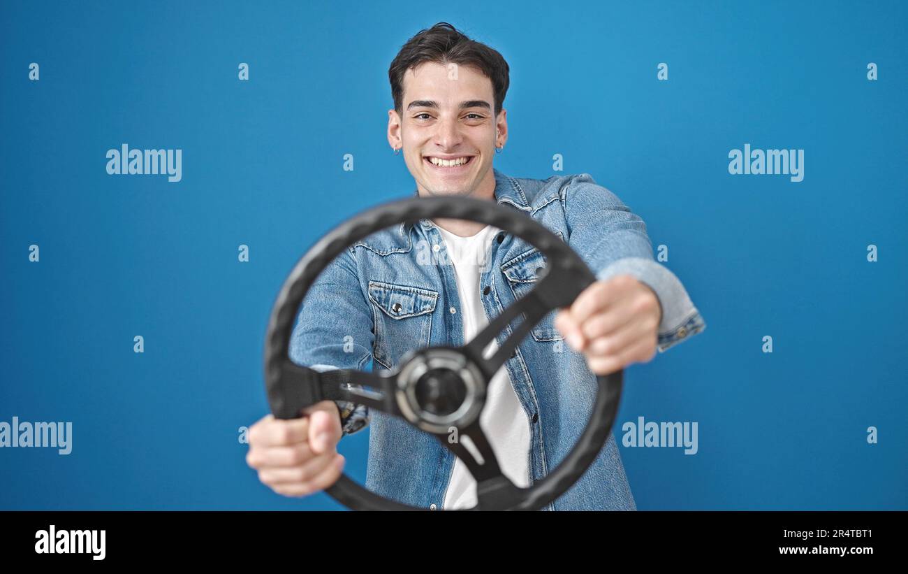 Young hispanic man smiling confident using steering wheel as a driver ...