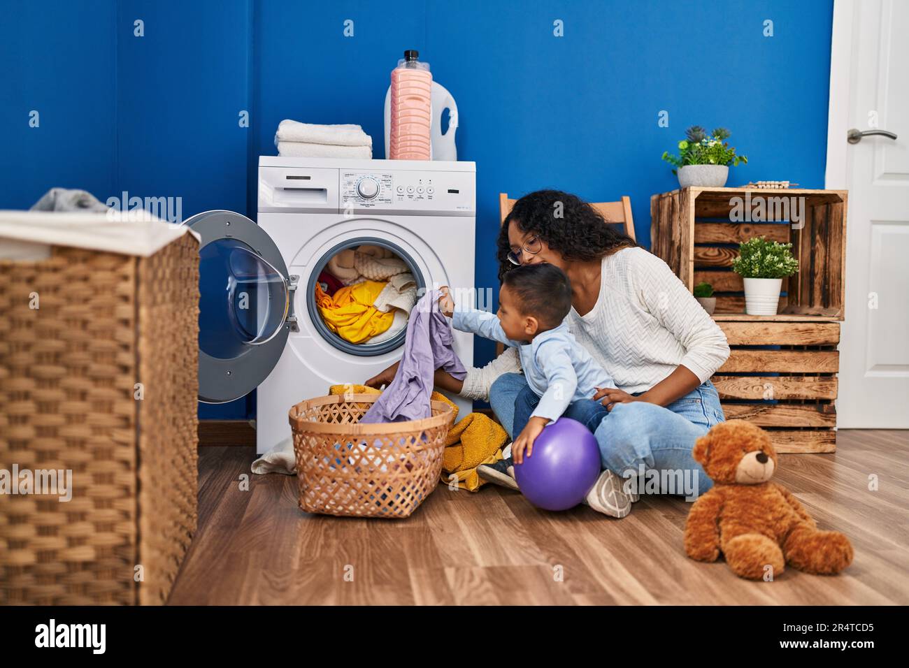 Mother and son smiling confident washing clothes at laundry room Stock ...