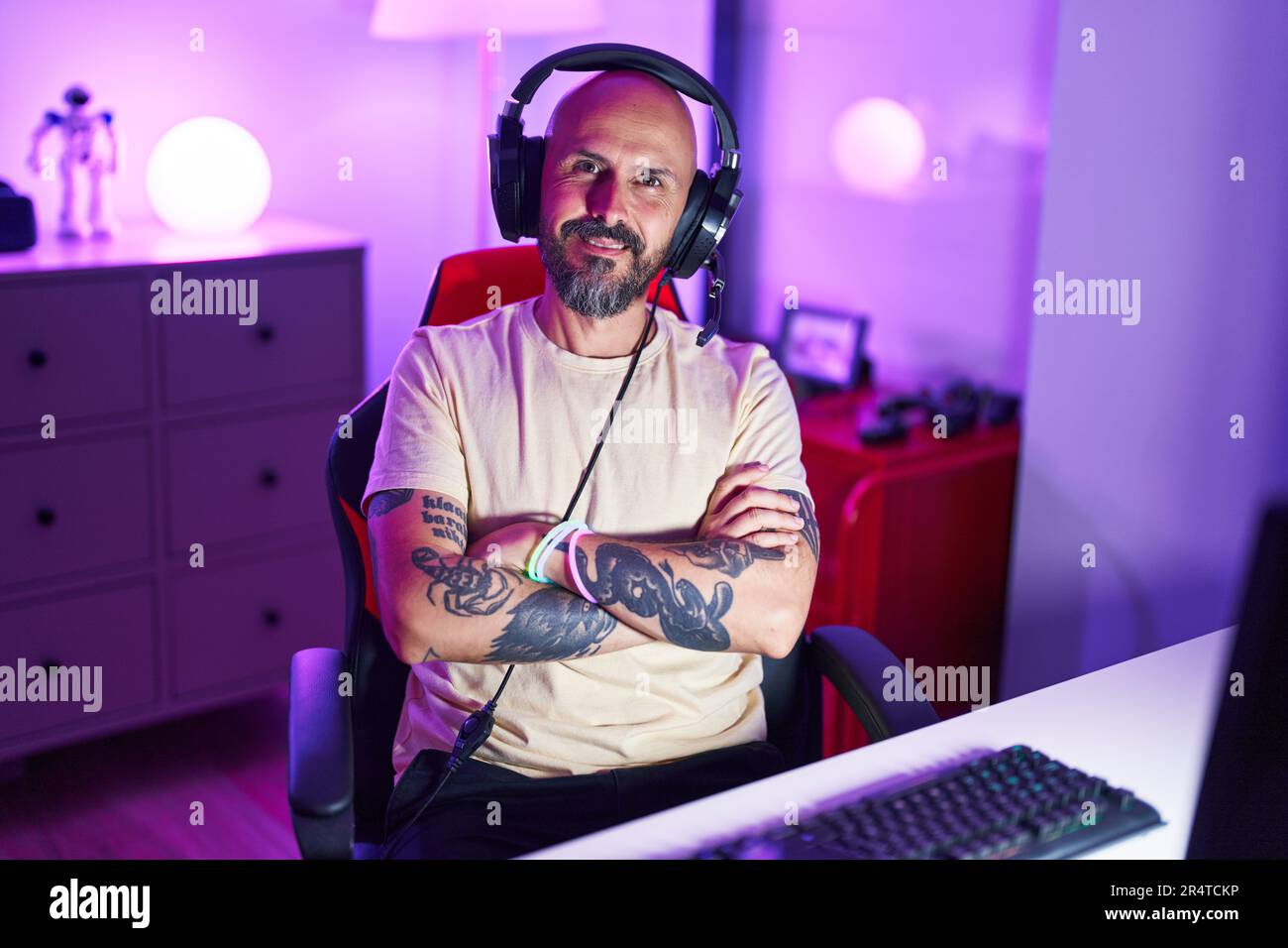 Young bald man streamer smiling confident sitting with arms crossed ...