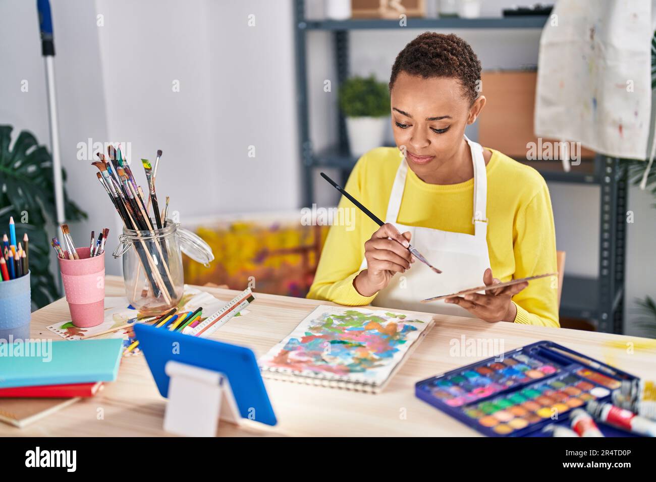 African american woman artist using touchpad drawing on notebook at art ...