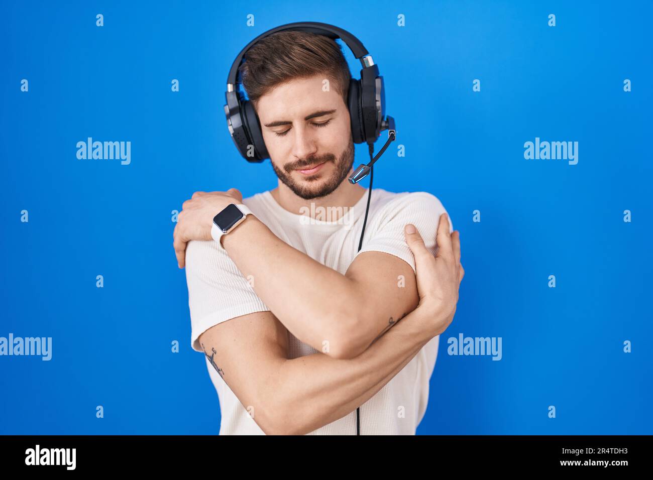 Hispanic Man With Beard Listening To Music Wearing Headphones Hugging