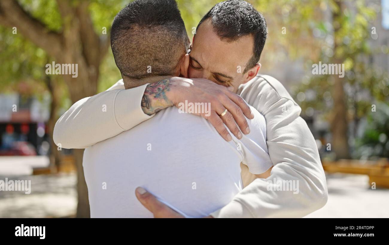 Two men couple smiling confident hugging each other at park Stock Photo ...