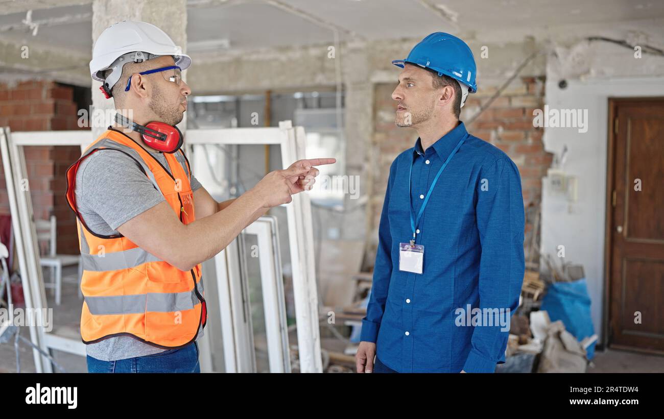 Two men builder and architect speaking at construction site Stock Photo ...