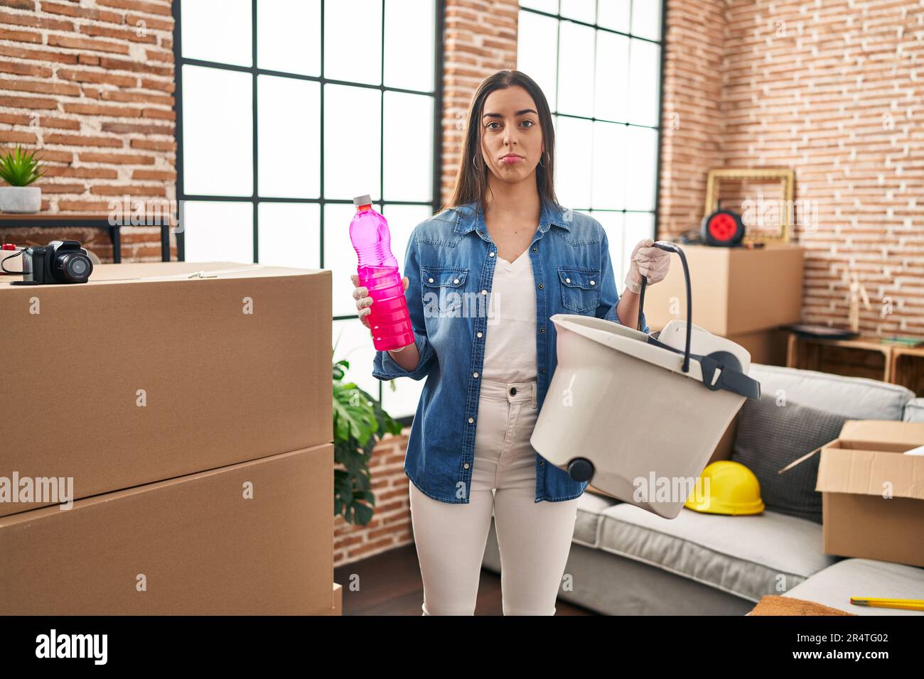 Hispanic woman moving to a new home cleaning the floor depressed and ...