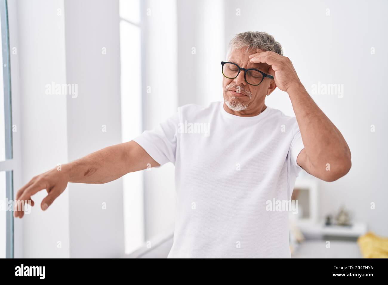 Middle age grey-haired man suffering dizzy standing at home Stock Photo ...