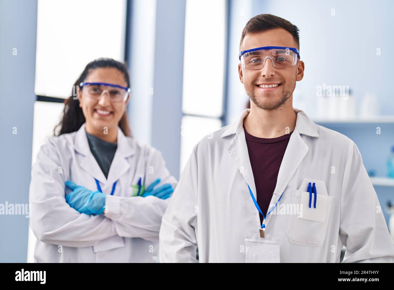Man and woman wearing scientist uniform standing with arms crossed ...