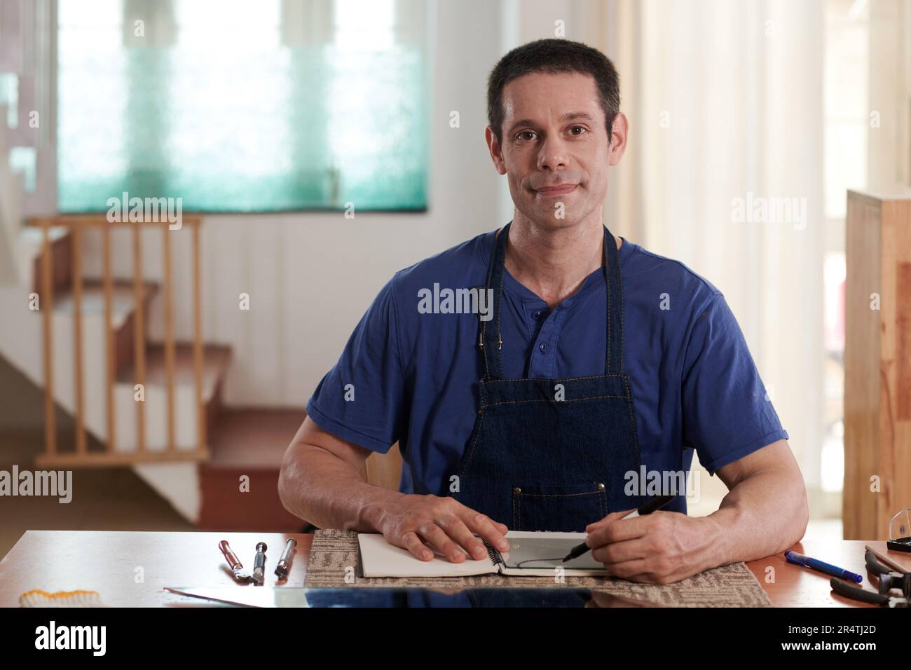 Craftsman drawing various shapes in notepad when working on collection ...