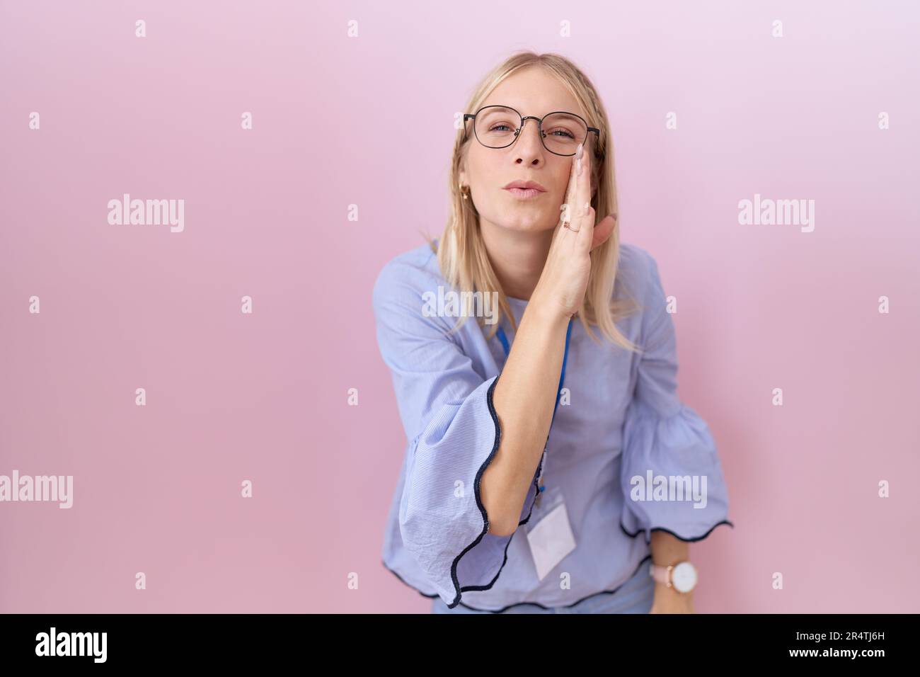 Young caucasian business woman wearing id card hand on mouth telling ...