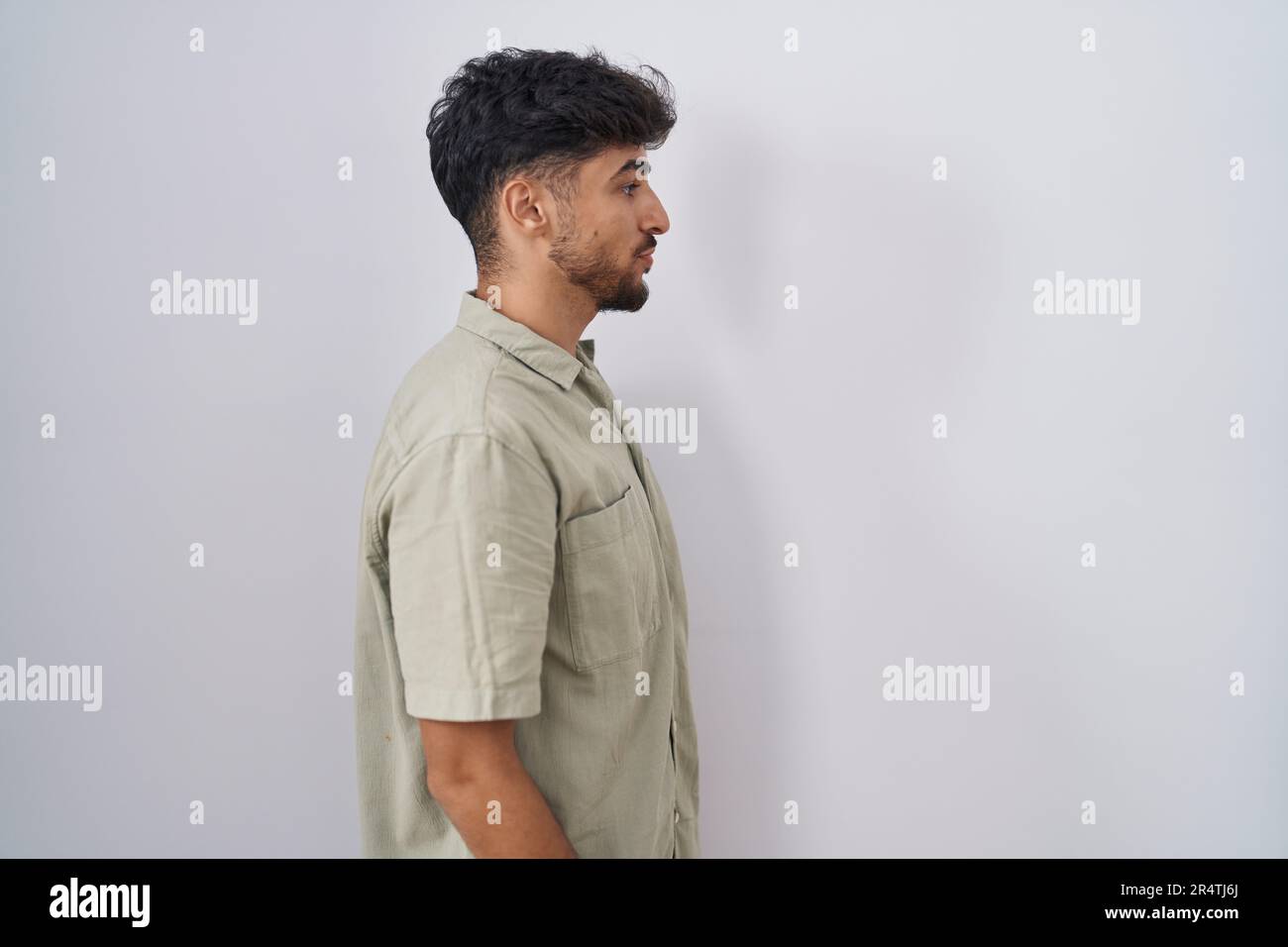 Arab man with beard standing over white background looking to side ...