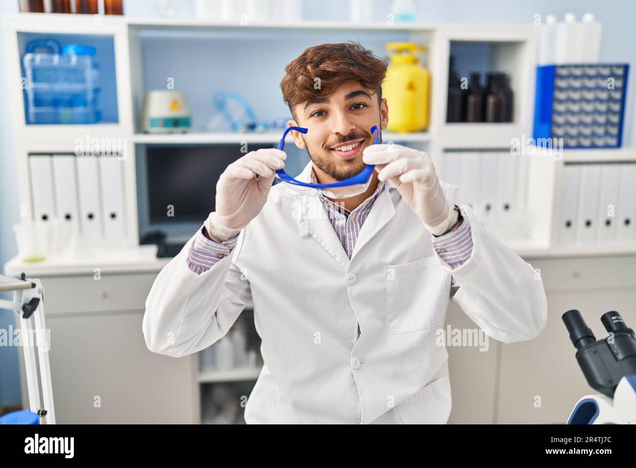 Young arab man scientist holding security glasses at laboratory Stock ...