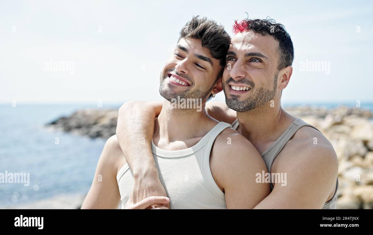 Two men couple smiling confident hugging each other at seaside Stock ...
