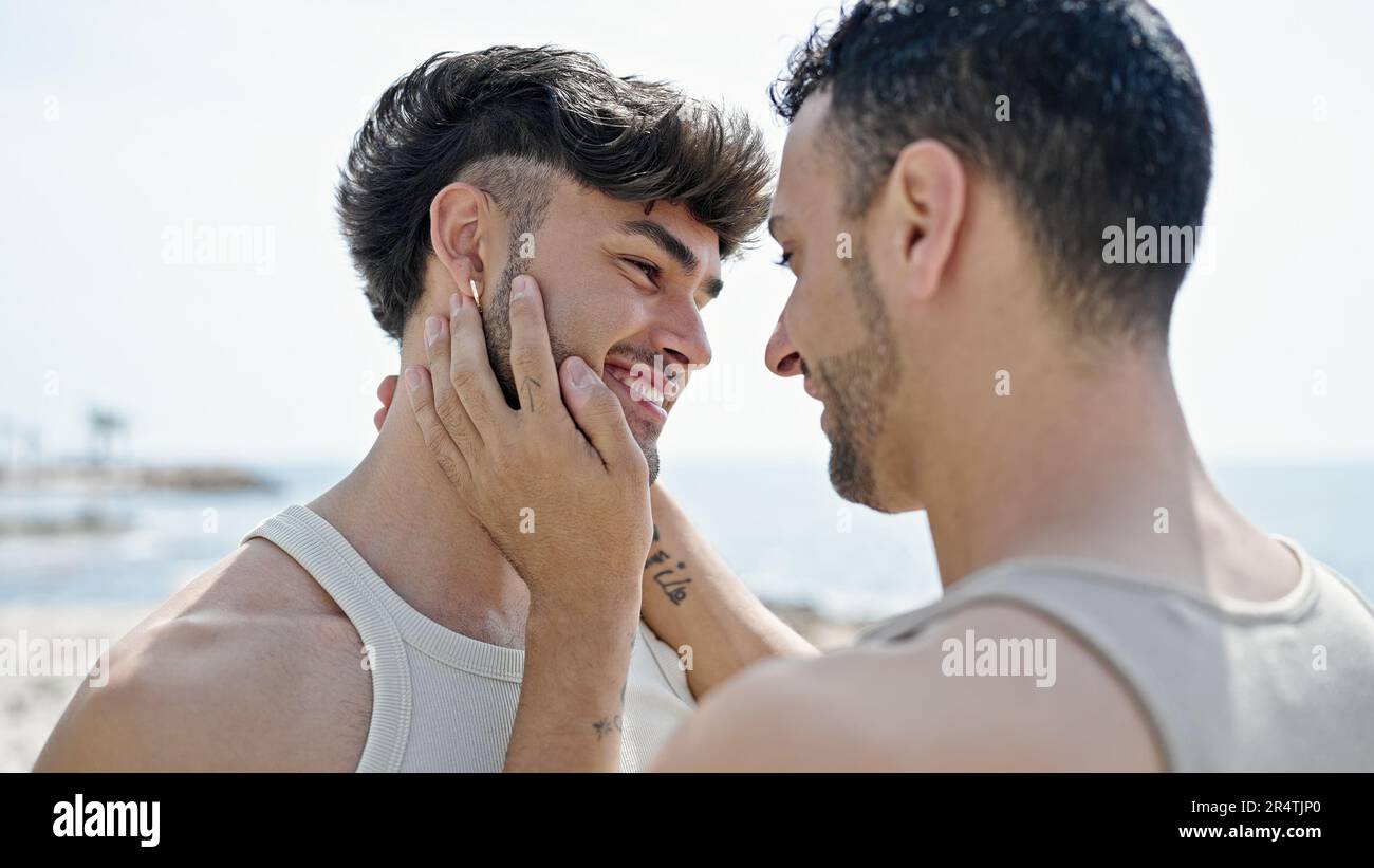 Two men couple smiling confident touching face at seaside Stock Photo ...