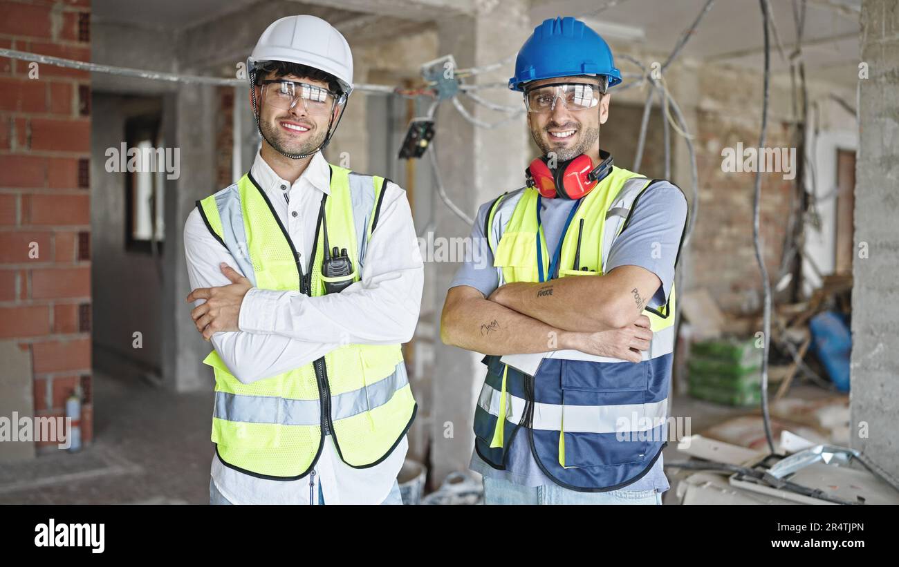Two men builders smiling confident standing with arms crossed gesture ...