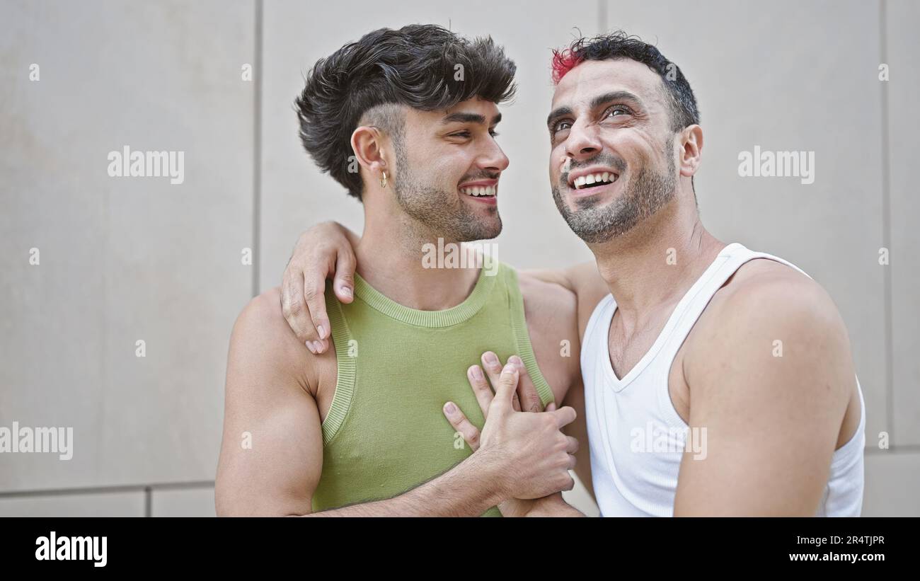Two men couple smiling confident hugging each other over isolated white ...
