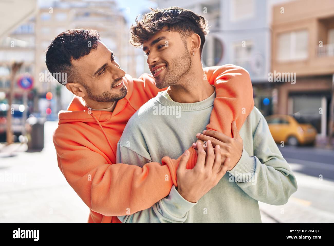 Two man couple hugging each other standing at street Stock Photo - Alamy