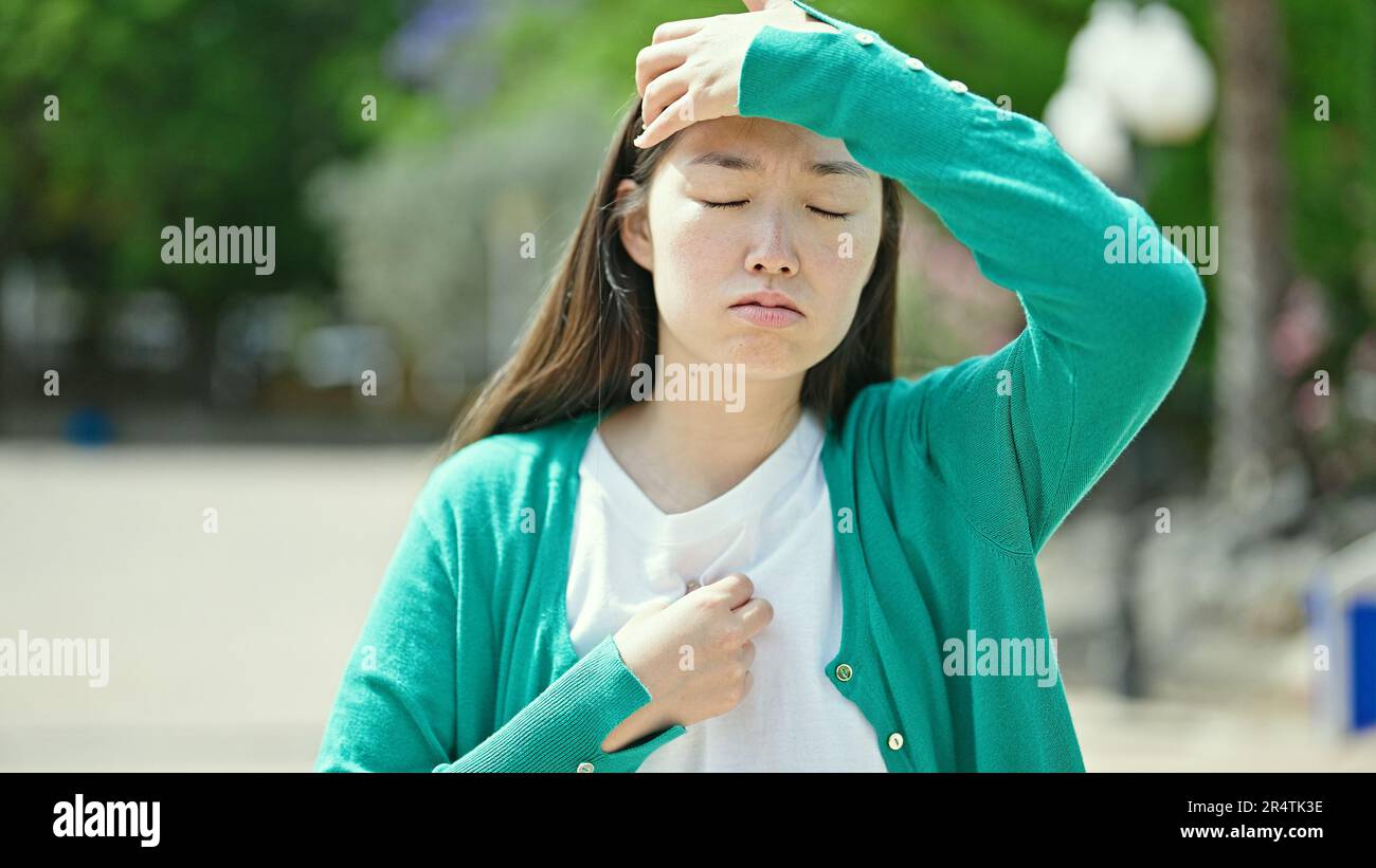 Young chinese woman suffering for headache at park Stock Photo - Alamy
