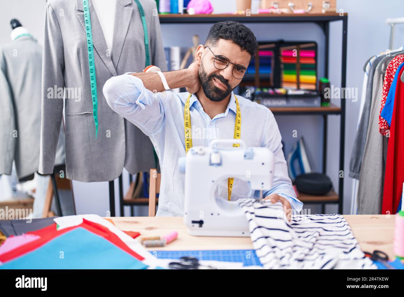 Young arab man tailor stressed using sewing machine at tailor shop ...