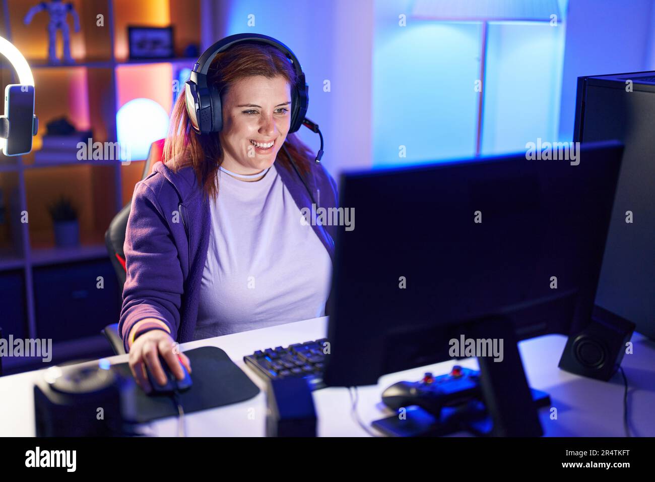 Young beautiful plus size woman streamer playing video game using ...