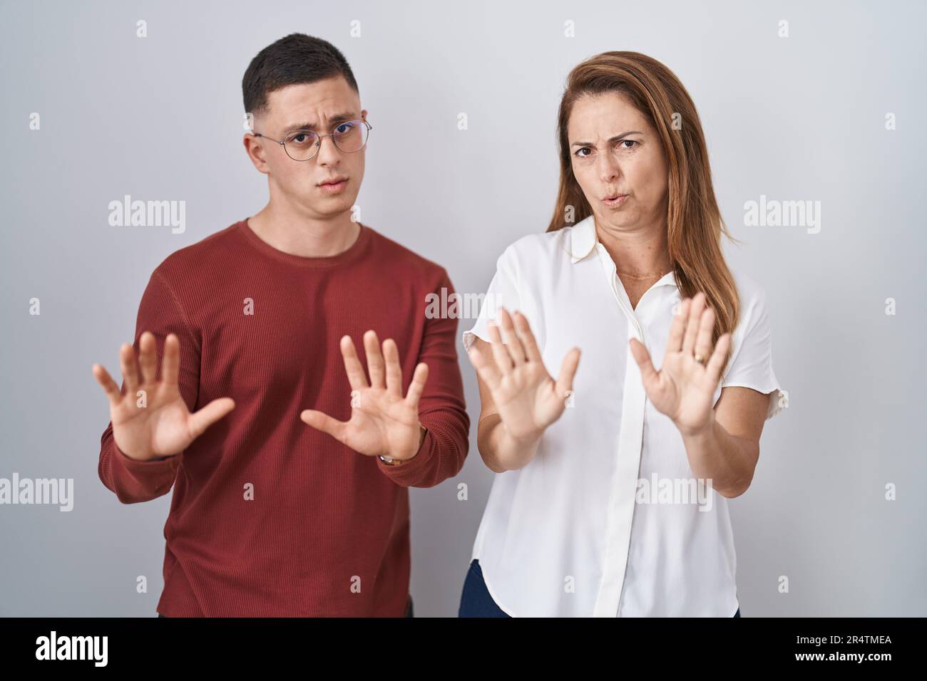 Mother and son standing together over isolated background moving away ...