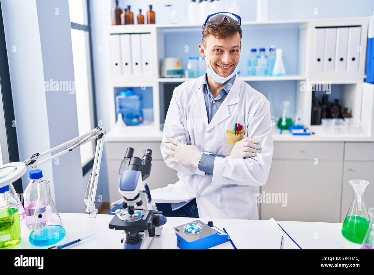 Caucasian man working at scientist laboratory happy face smiling with ...