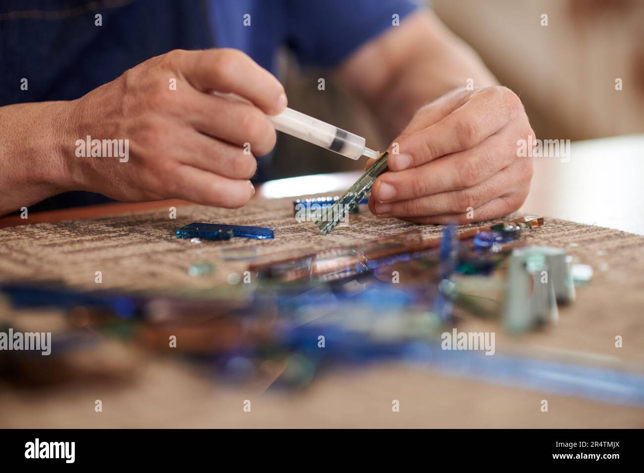 Hands of worker glueing piece of glass for project Stock Photo - Alamy