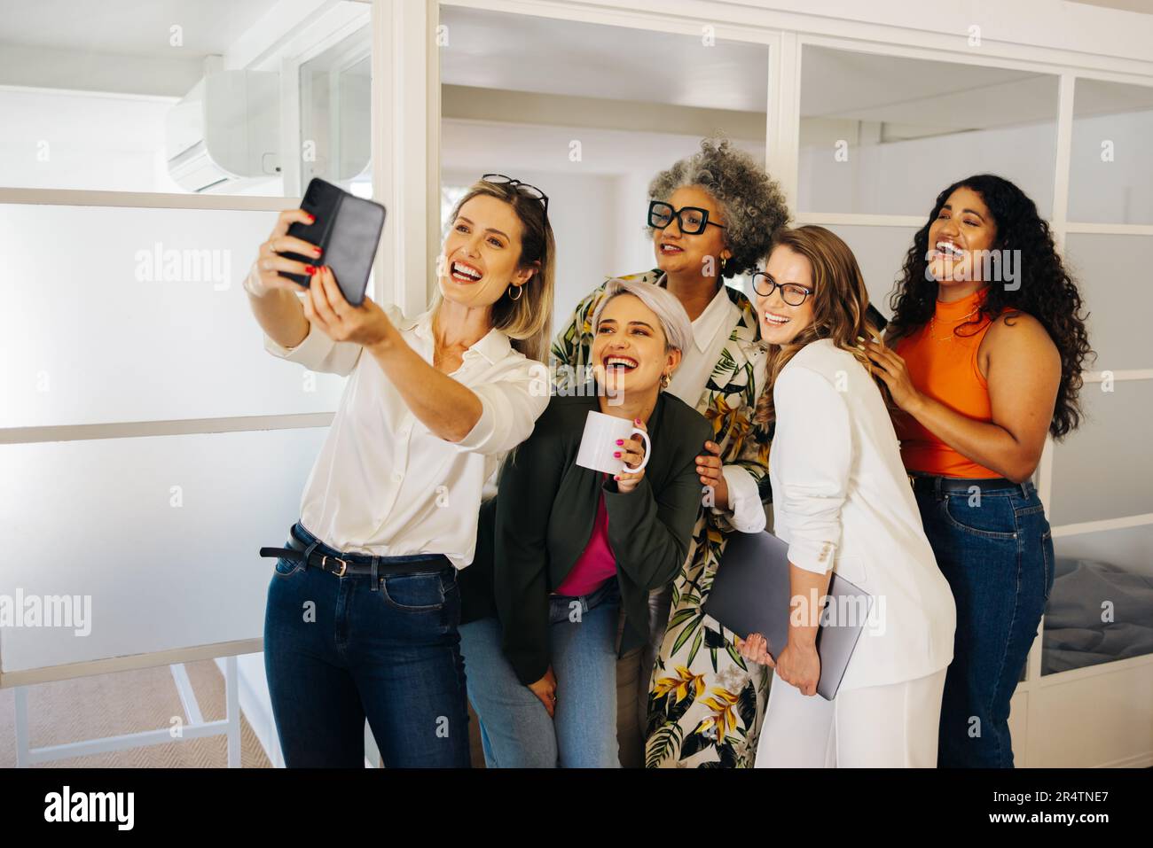 Diverse businesspeople smiling cheerfully while taking a selfie ... Diverse businesspeople smiling cheerfully while taking a selfie ...