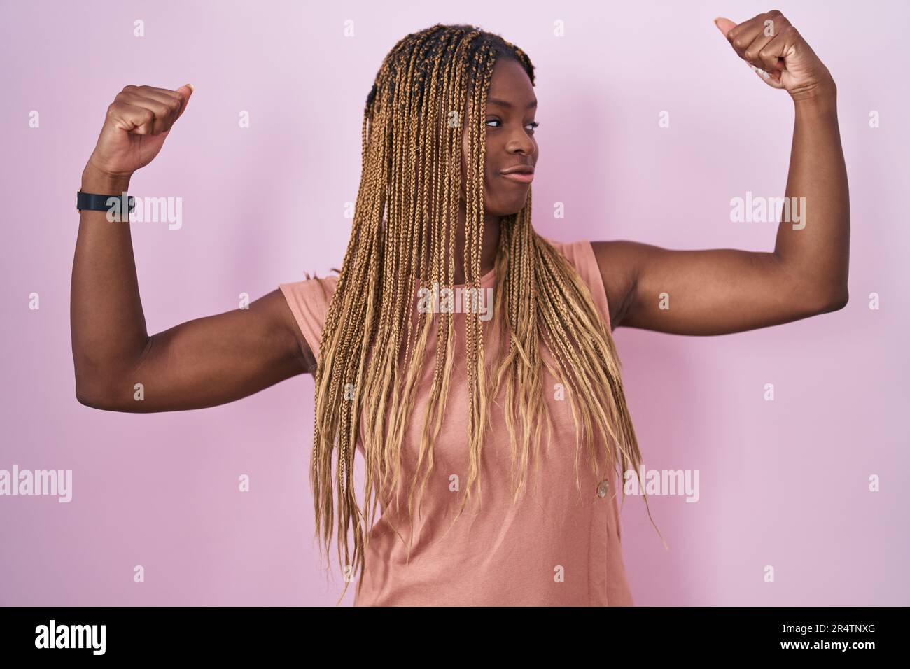 African american woman with braided hair standing over pink background ...