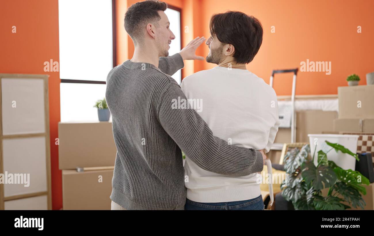 Two men couple hugging each other speaking at new home Stock Photo - Alamy