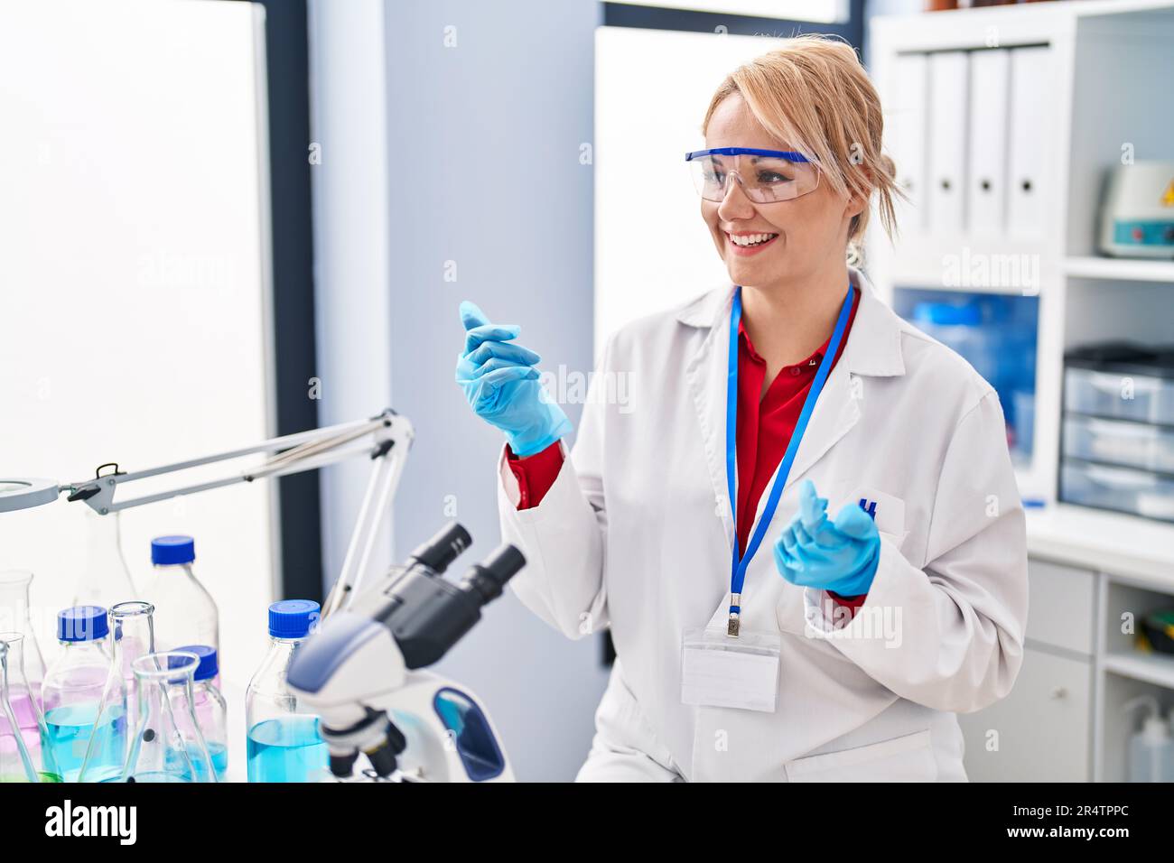 Young blonde woman scientist smiling confident speaking at laboratory ...