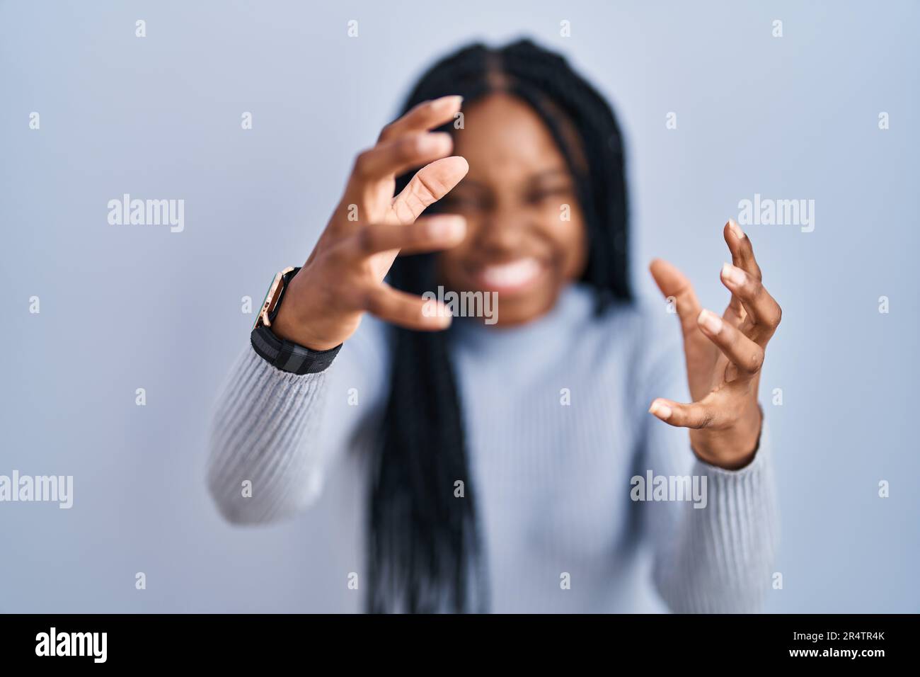 African american woman standing over blue background shouting ...