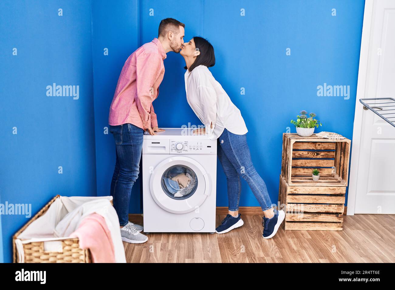 Man and woman couple washing clothes kissing at laundry room Stock Photo - Alamy