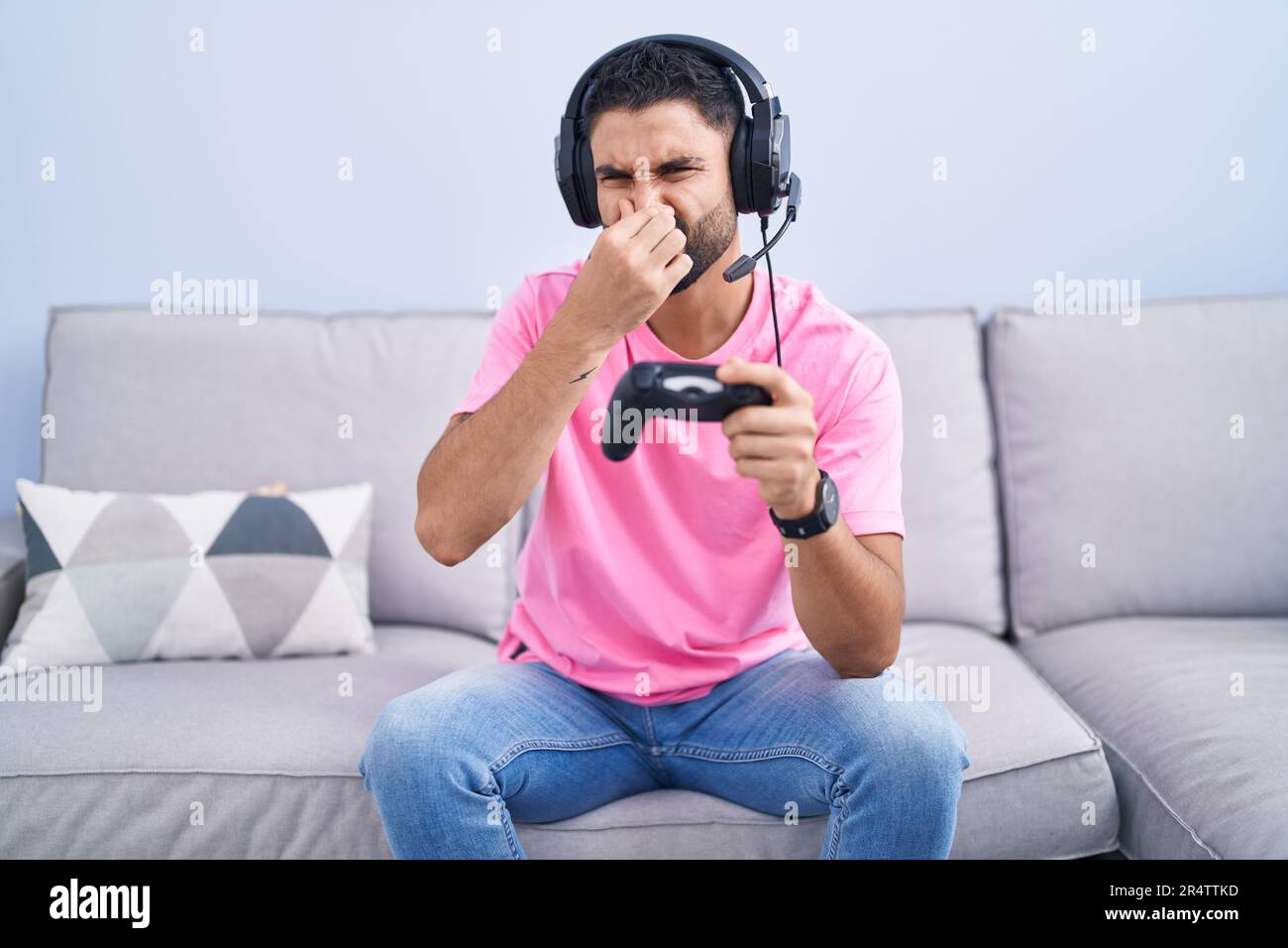 Hispanic young man playing video game holding controller sitting on the ...