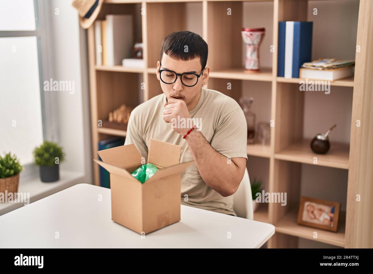 Young arab man with open gift in cardboard box feeling unwell and ...