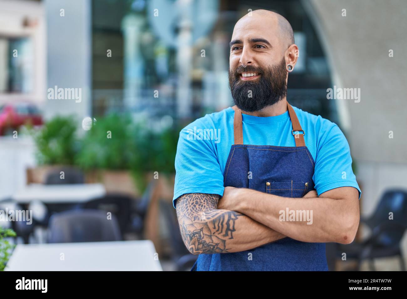 Young bald man waiter smiling confident standing with arms crossed ...