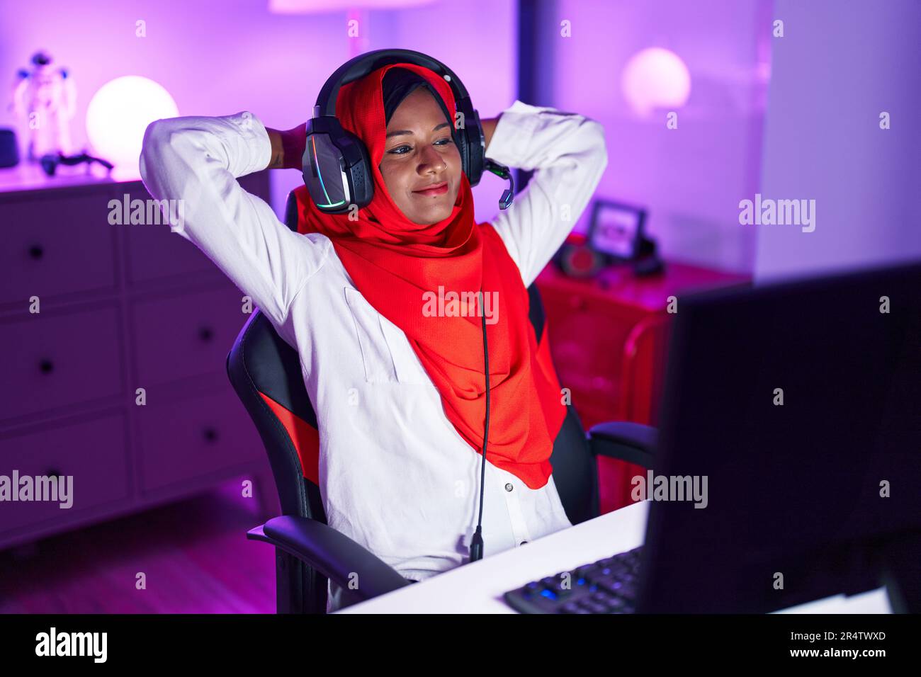 Young beautiful woman streamer playing video game relaxed with hands on ...