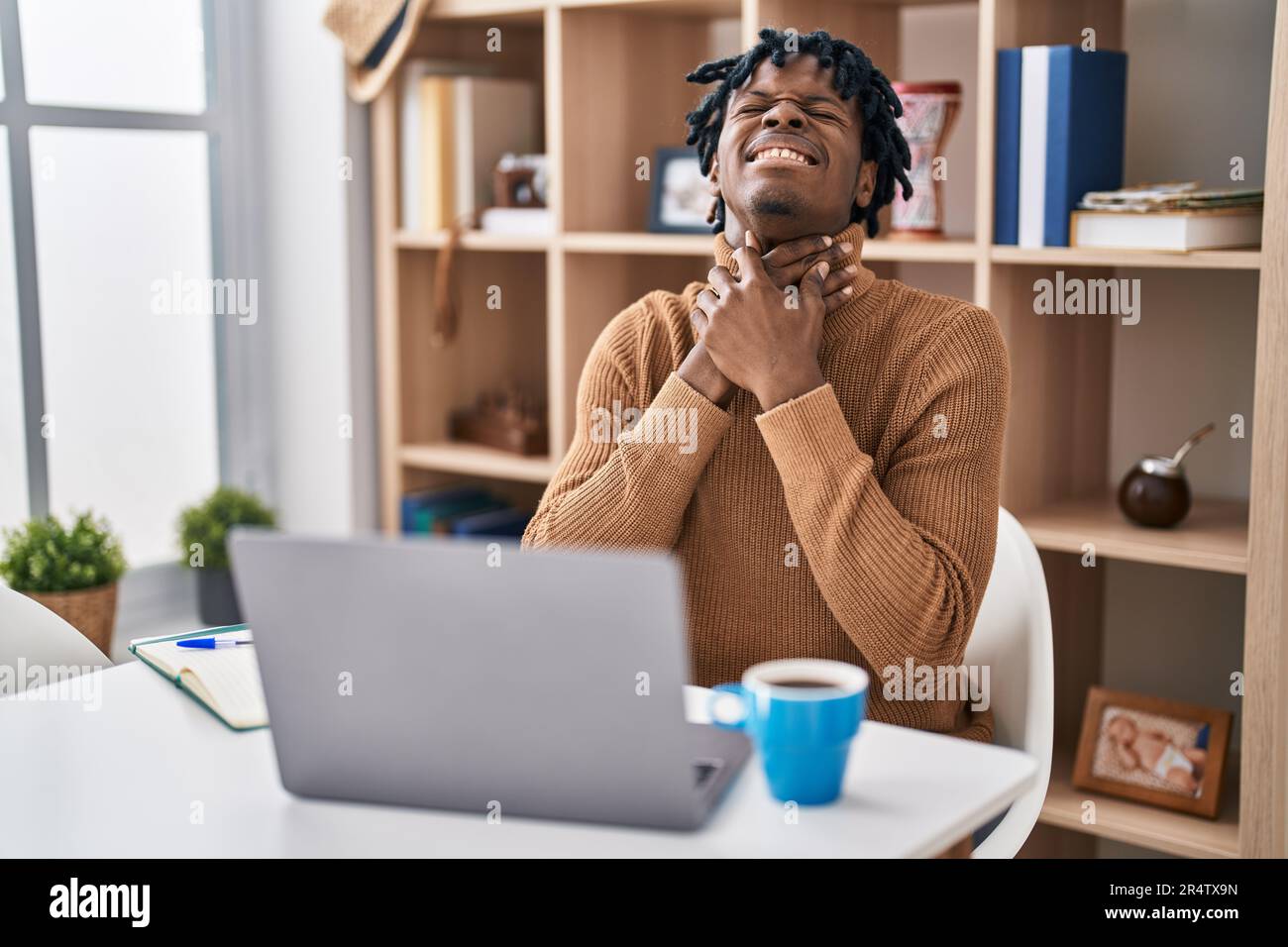Young african man with dreadlocks working using computer laptop ...