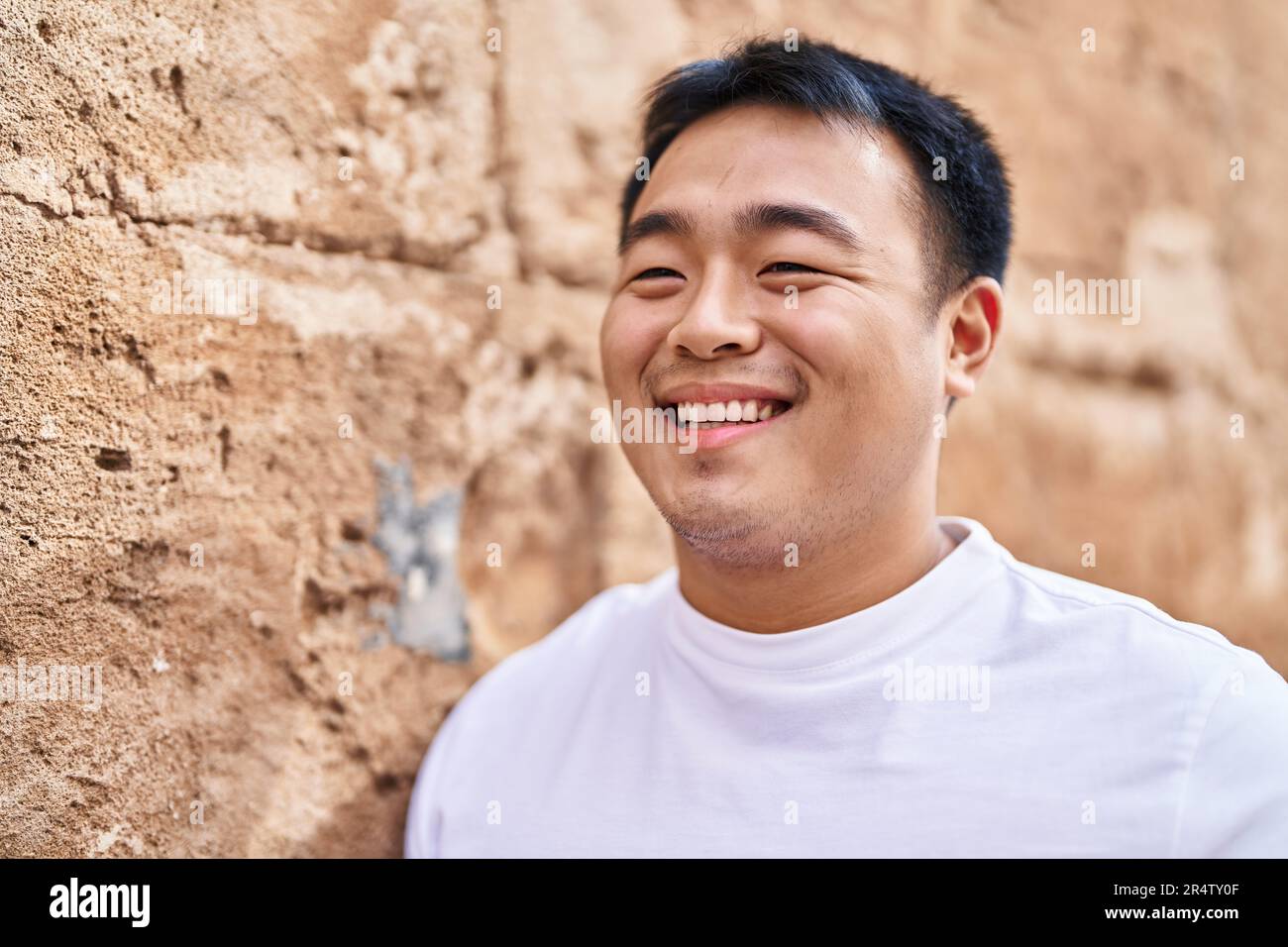 Young chinese man smiling confident standing at street Stock Photo - Alamy