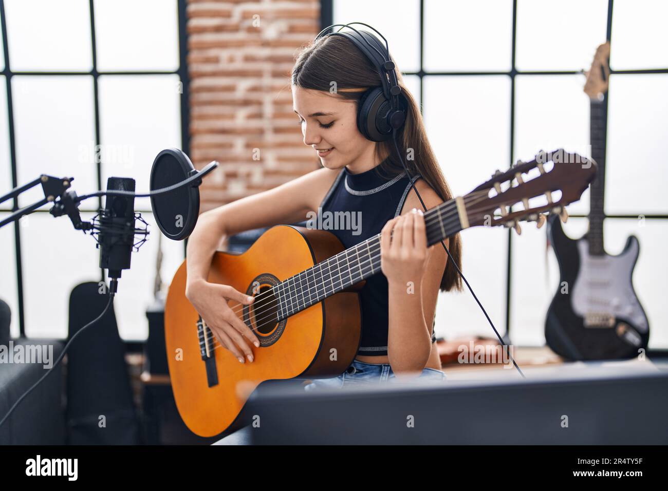 Adorable girl musician singing song playing classical guitar at music ...