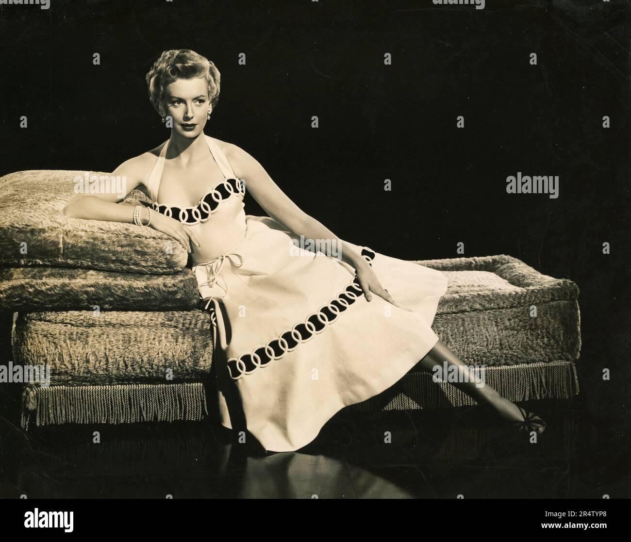 American actress Deborah Kerr wearing a white dress laying on the sofa ...