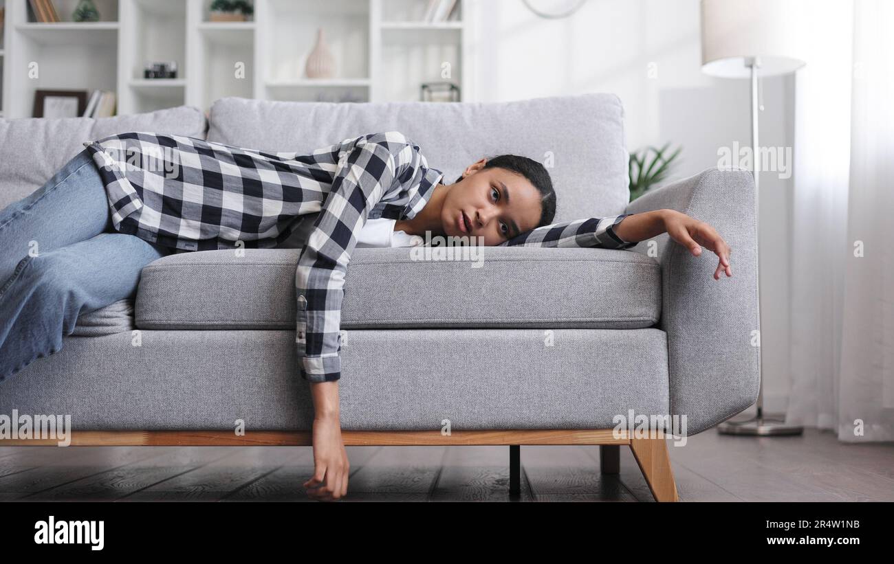 Tired african american girl lying on sofa feeling lethargic. Fee Stock ...