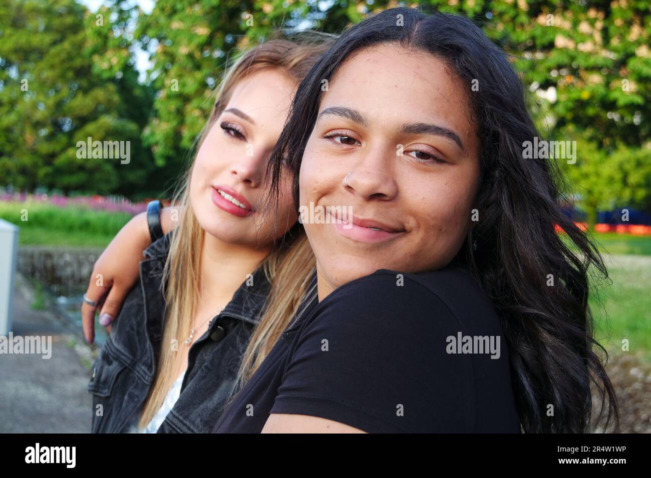 2 Gorgeous Young English Girls Are Posing While Sitting On A Bench At Local Public Park And Edge