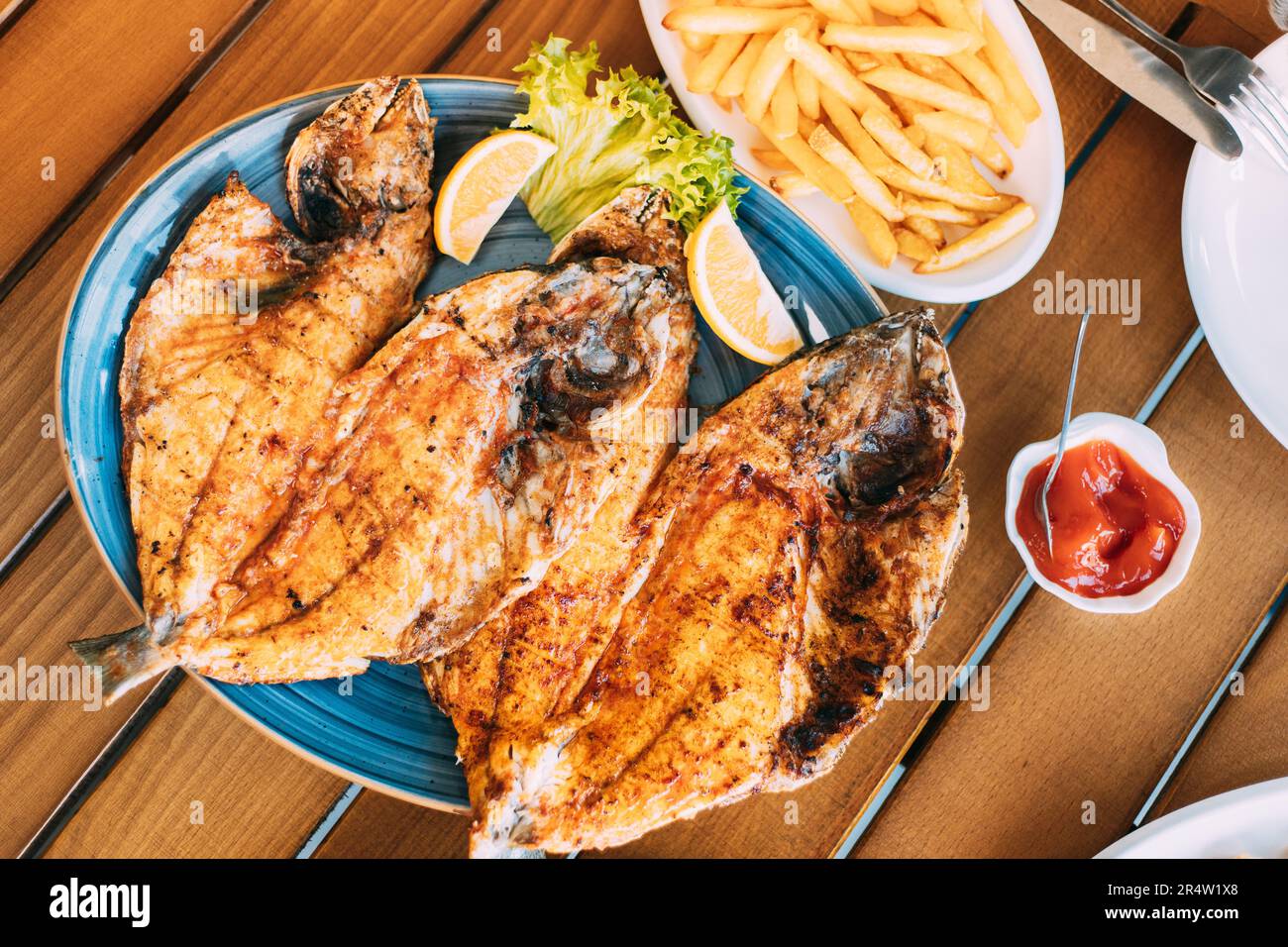 Dish with Gilt-head bream Fish With orange and french fries. Dorada ...