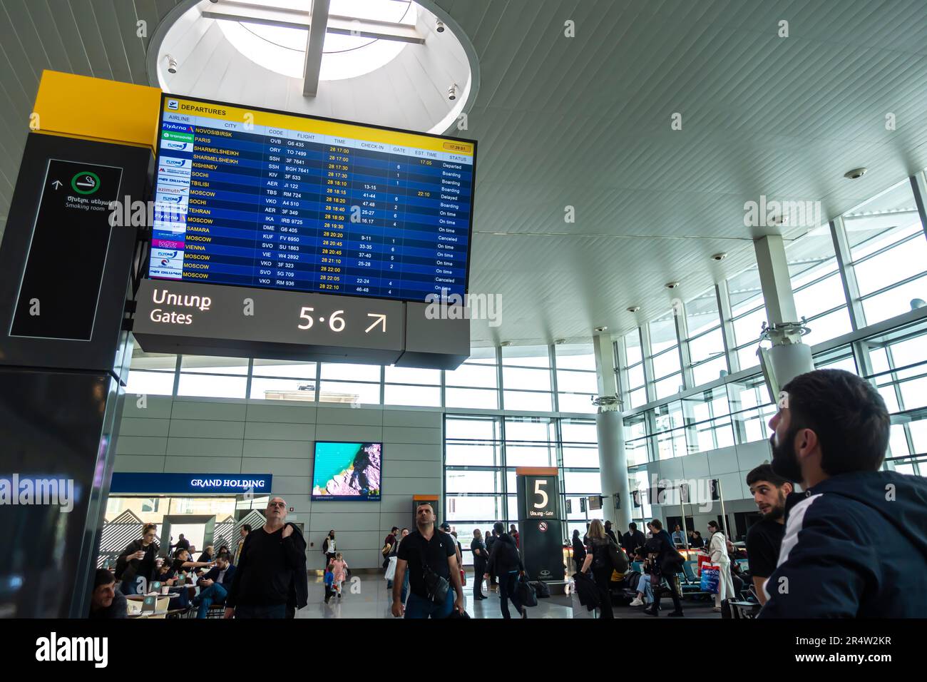 Passengers looking at flights information in the terminal of Zvartnots ...