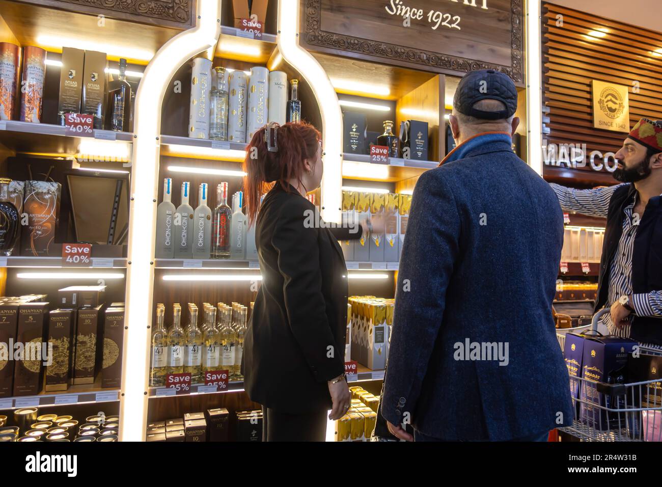A shop employee staff member selling alcohol to passengers at the ...