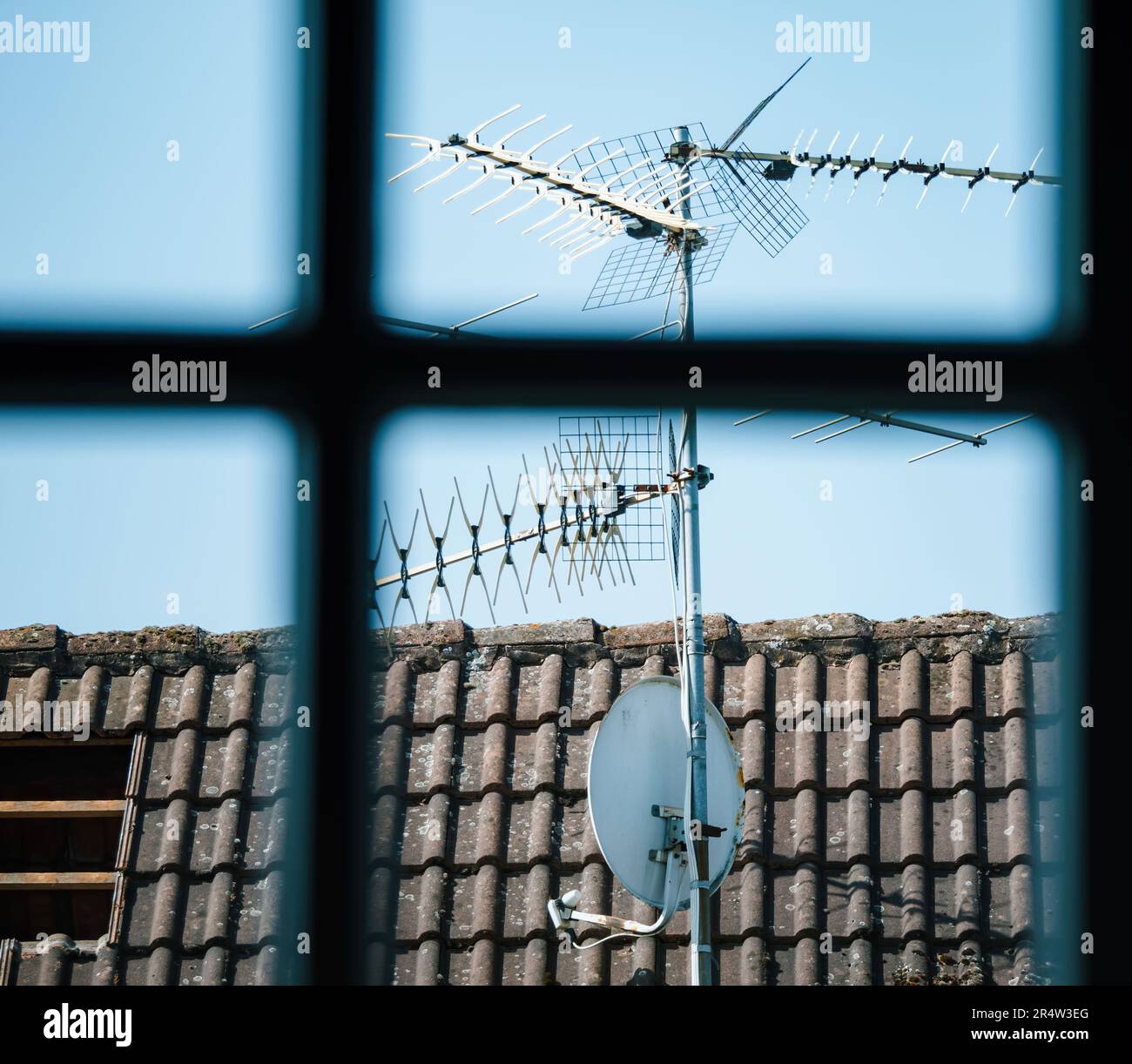 A stunning view of a blue-tiled roof filled with diverse antennas seen ...