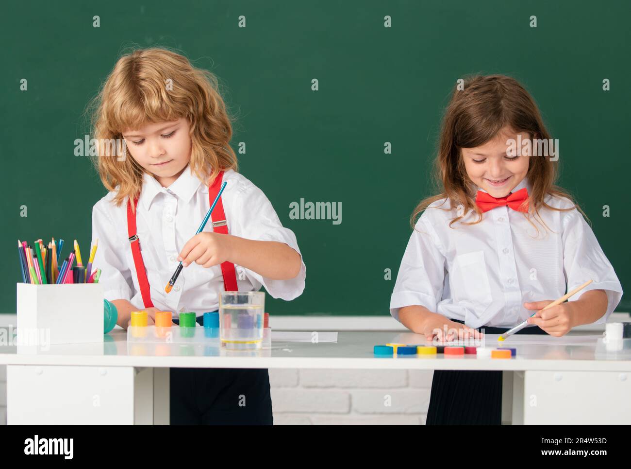 School children drawing a colorful pictures with pencil crayons in ...