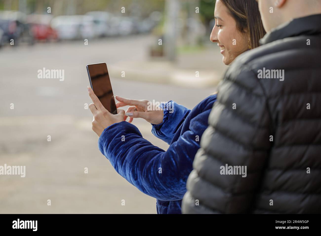 Girl shows her mobile phone to a guy Stock Photo - Alamy